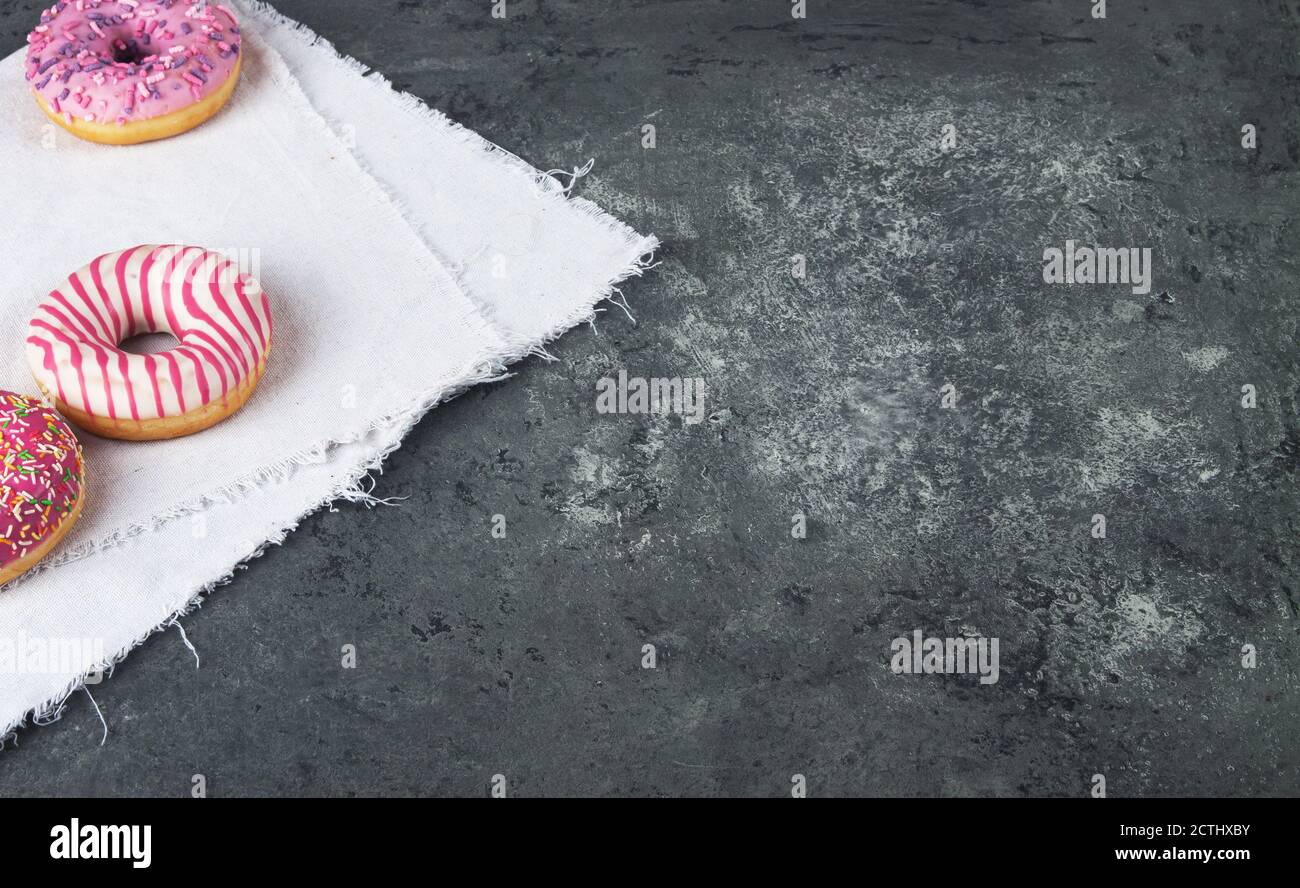 Baked sweet delicious donuts with pastry crumb on gray concrete ...