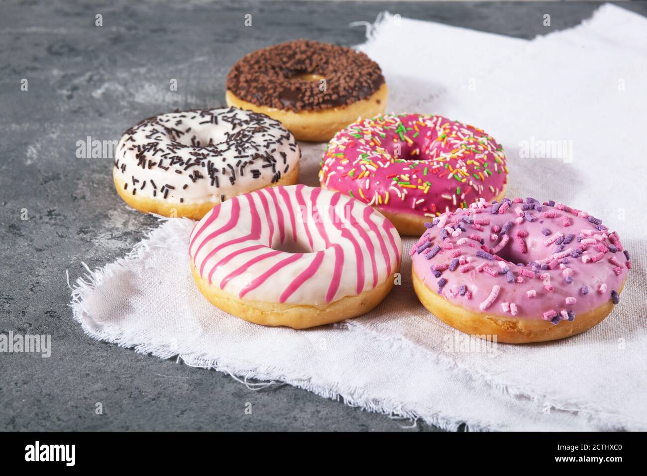 Baked sweet delicious donuts with pastry crumb on gray concrete ...