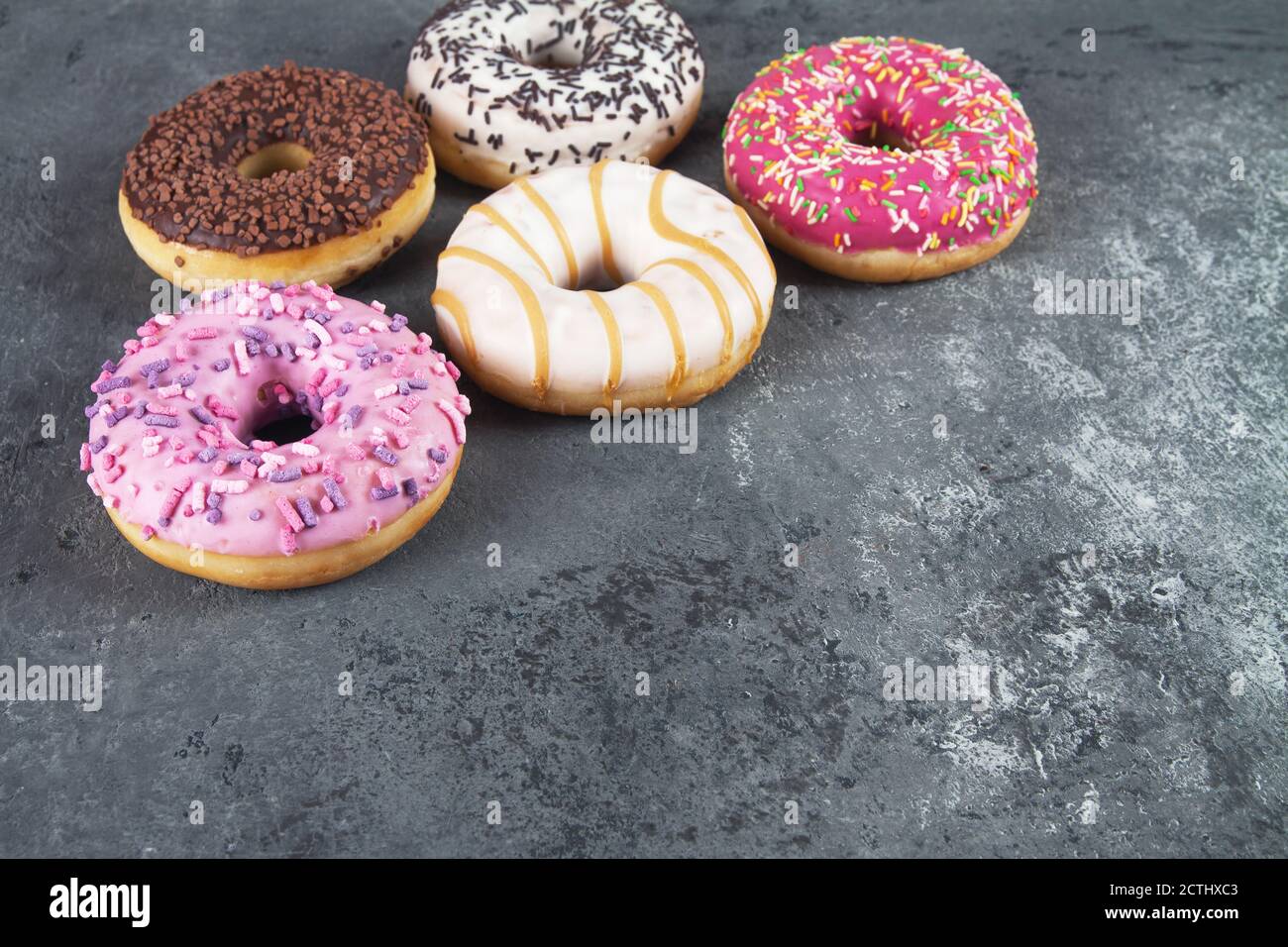 Baked sweet delicious donuts with pastry crumb on gray concrete ...
