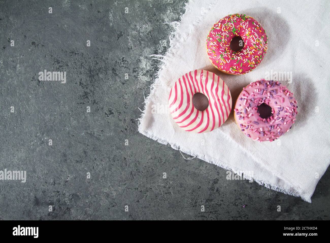 Baked sweet delicious donuts with pastry crumb on gray concrete ...