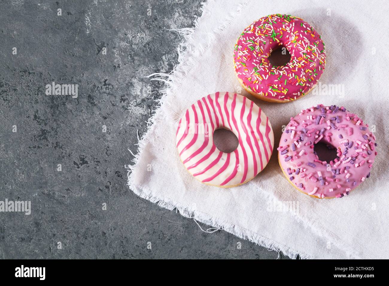 Baked sweet delicious donuts with pastry crumb on gray concrete ...
