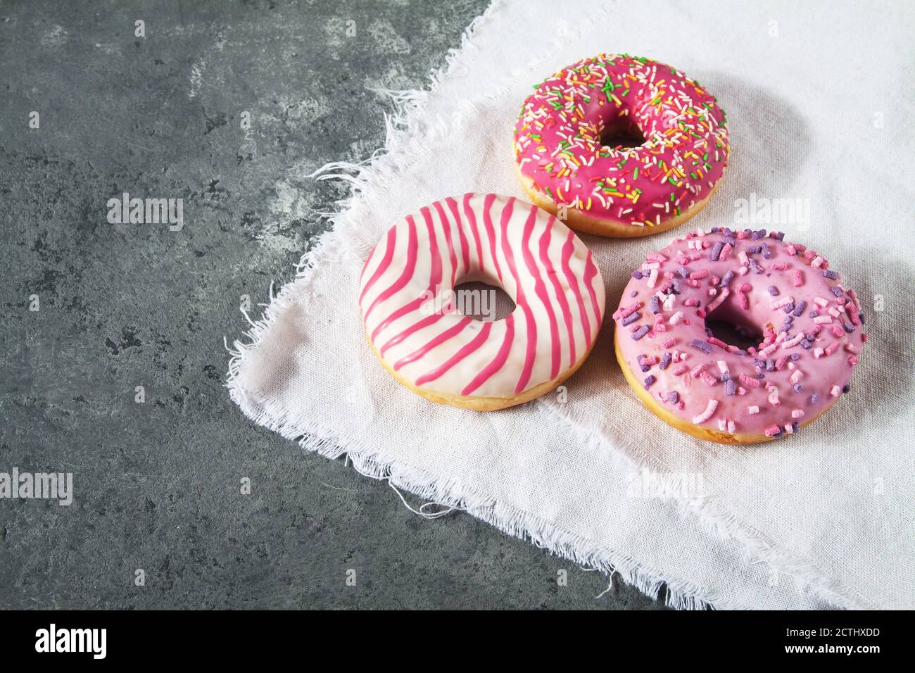 Baked sweet delicious donuts with pastry crumb on gray concrete ...