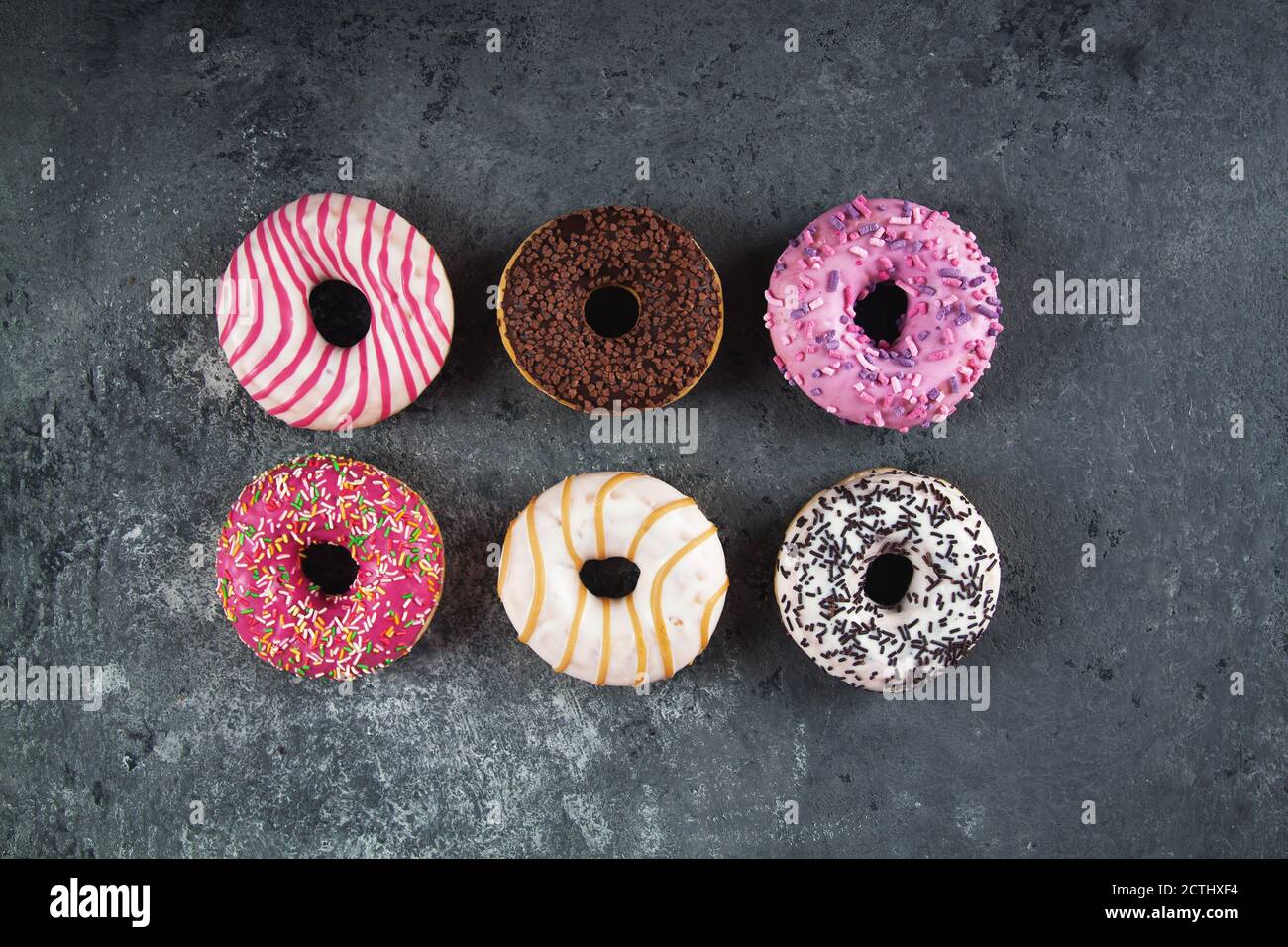 Baked sweet delicious donuts with pastry crumb on gray concrete ...