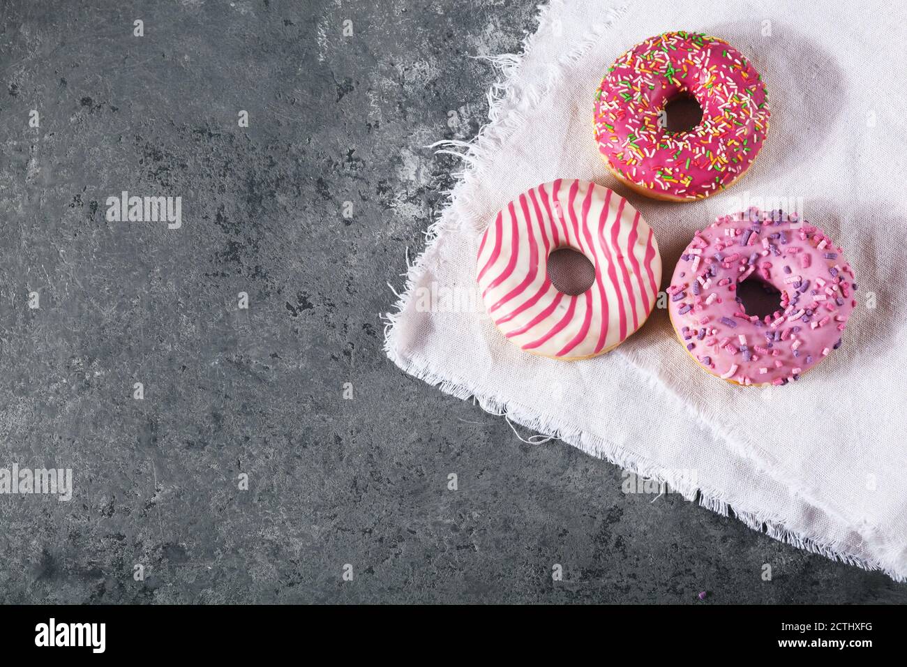 Baked sweet delicious donuts with pastry crumb on gray concrete ...