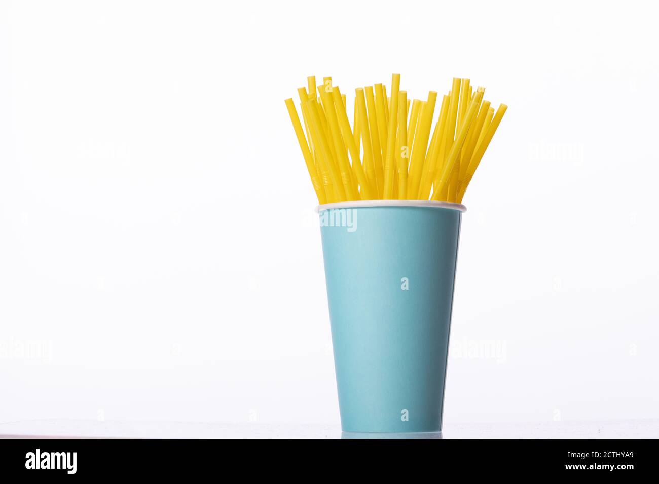Bunch of yellow plastic straws in blue disposable biodegradable paper ...
