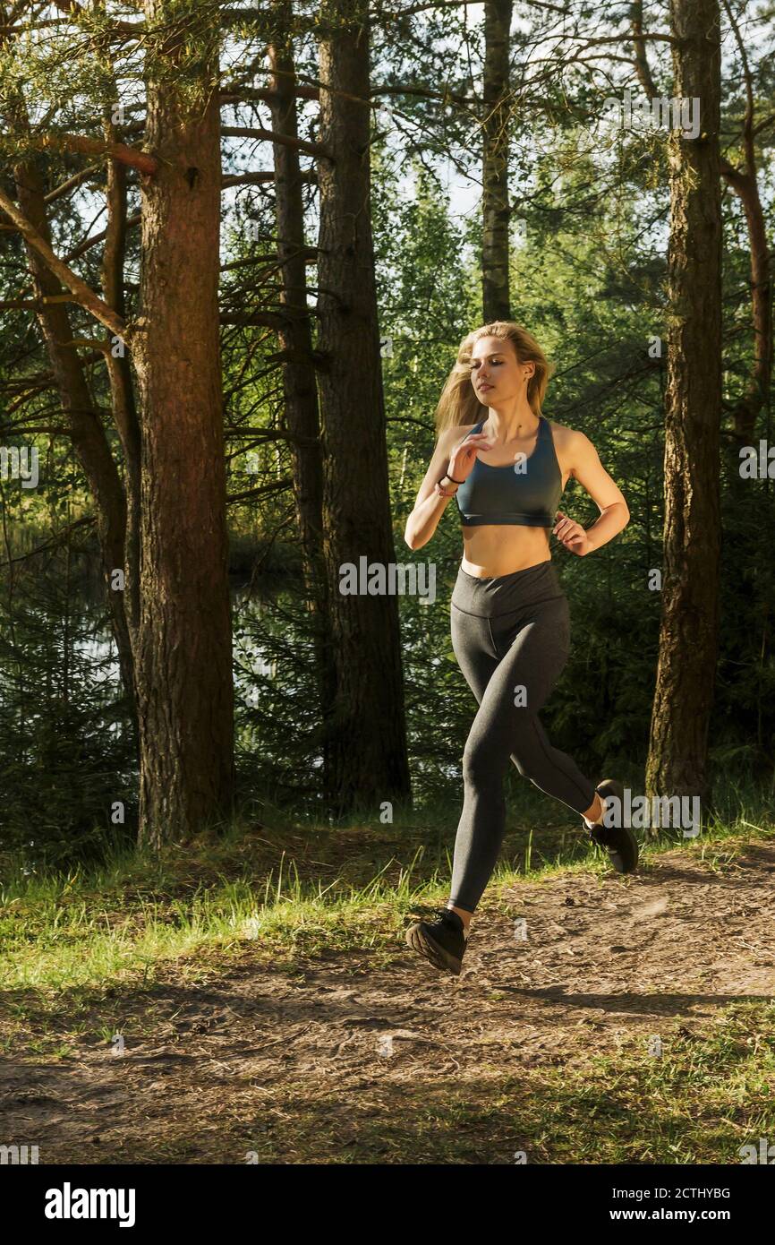 Young slim athletic woman getting ready for a marathon while running ...