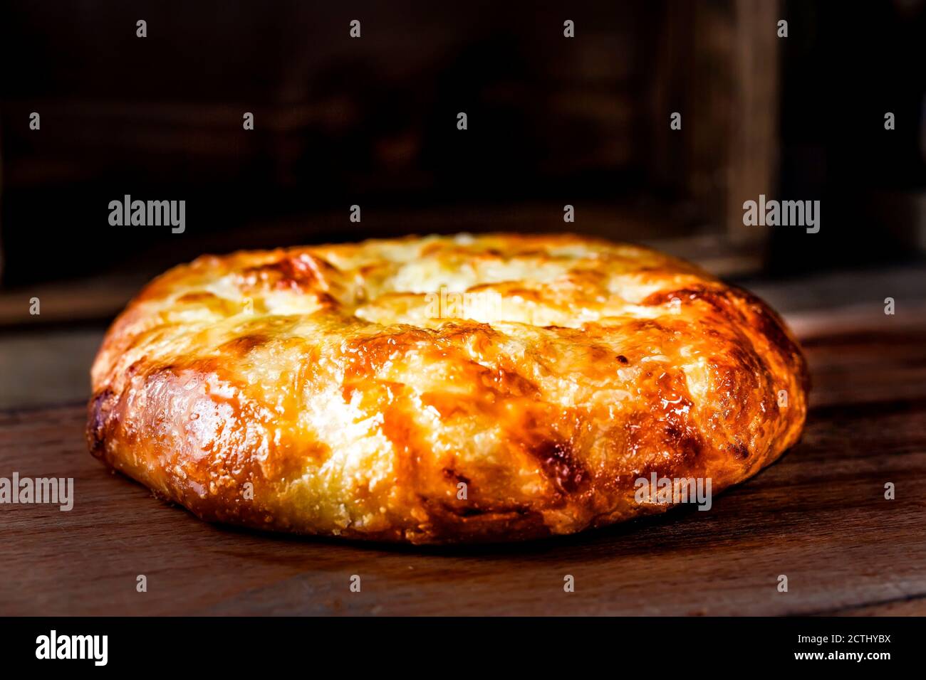 Eastern Turkish cheese cake lies on a wooden table. Pita with cheese ...
