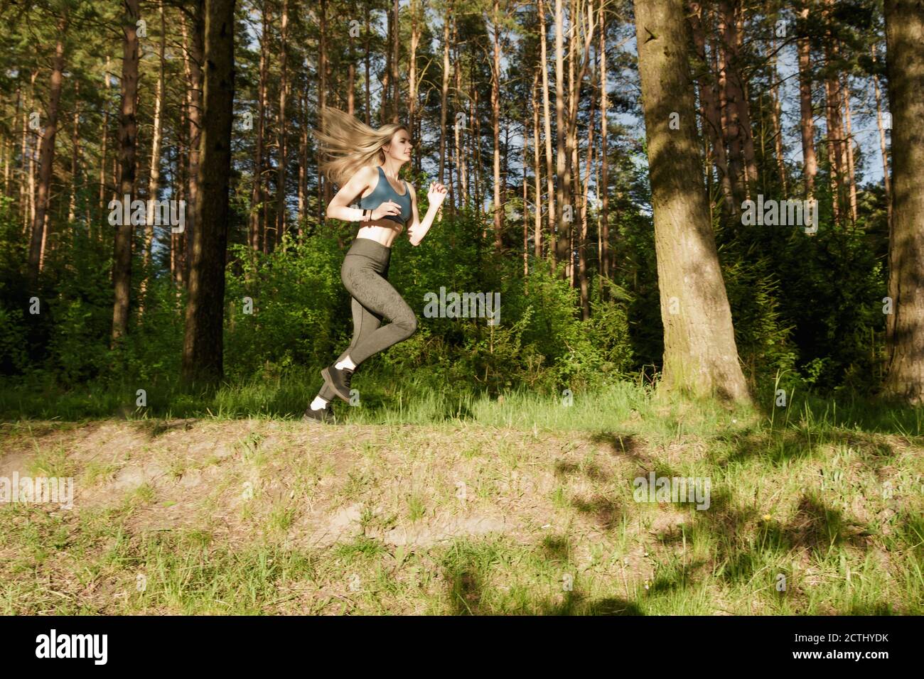 Young slim athletic woman getting ready for a marathon while running ...