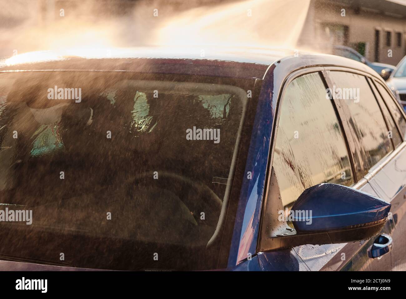 Manual car washing using a high pressure water. Side view of cleaning ...