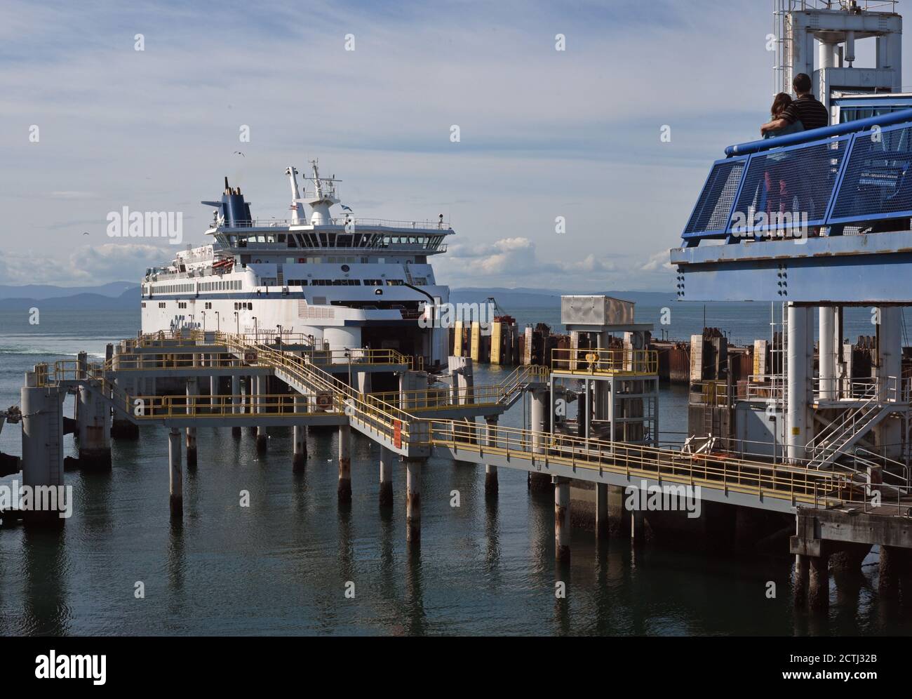 A couple watches from an outside deck at the BC Ferries’ Tsawwassen ...