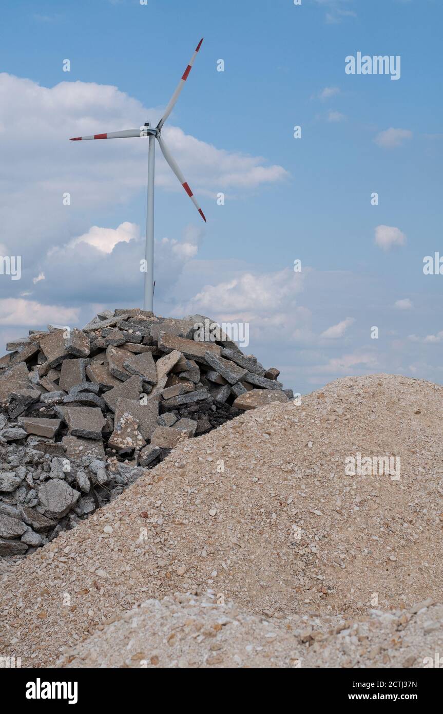 view over heaps of gravel and rubble to a wind turbine Stock Photo - Alamy