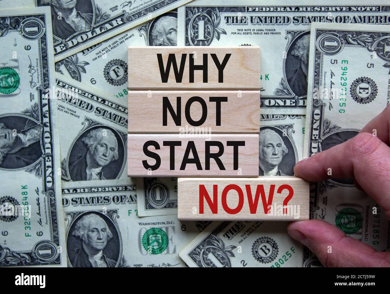 Male hand placing a block with word 'now' on a blocks tower with words ...