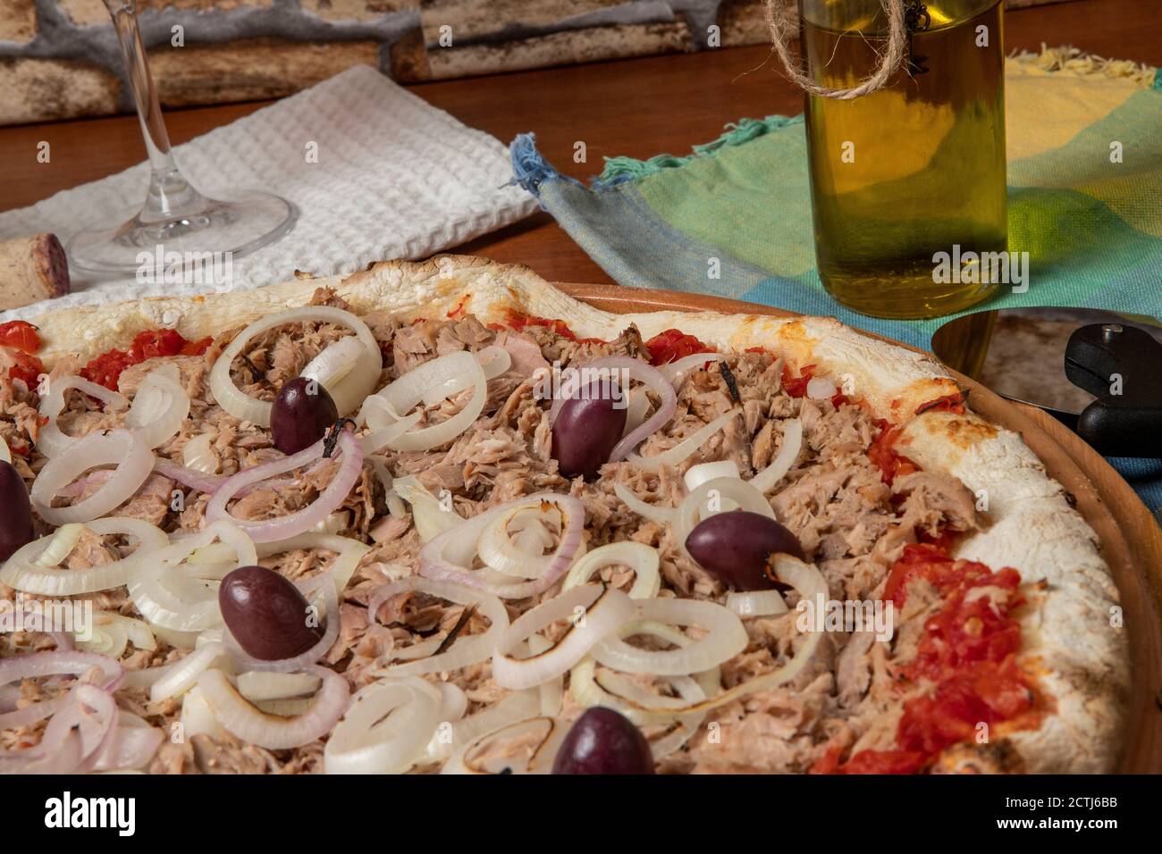 Pizza tuna fish, onion, tomato and black olive on wooden table ...