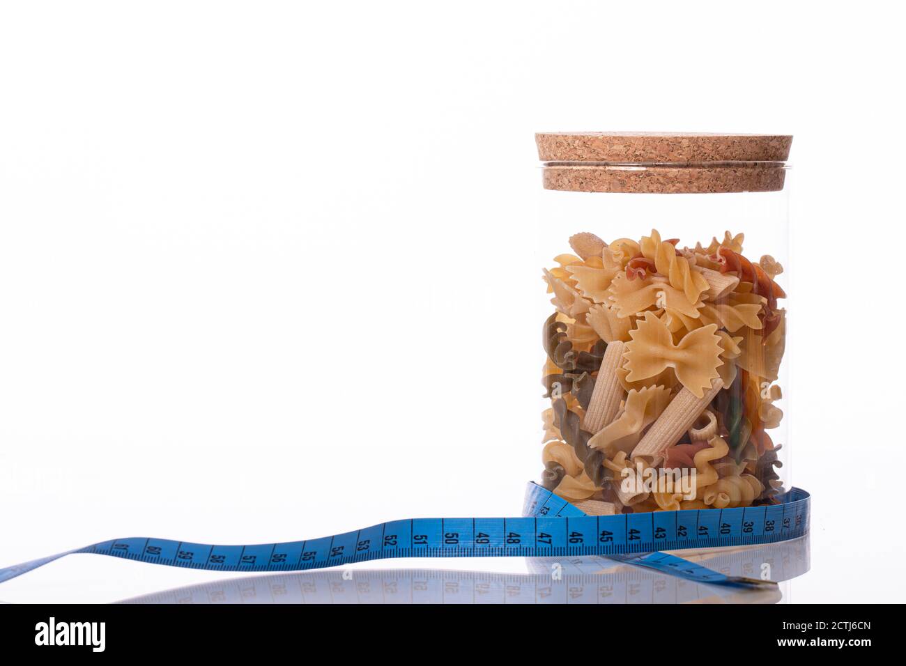 Mix of raw pasta in jar and measuring tape isolated on white background ...