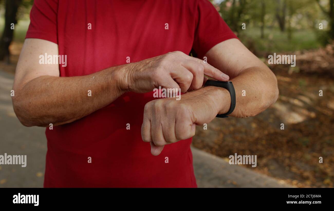 Adult runner man starting tapping touchscreen on smart watch, tracking ...