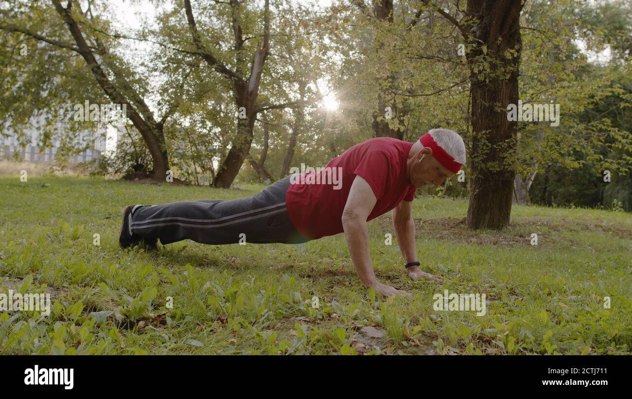 Active senior elderly 80 years old caucasian man doing morning push-ups ...