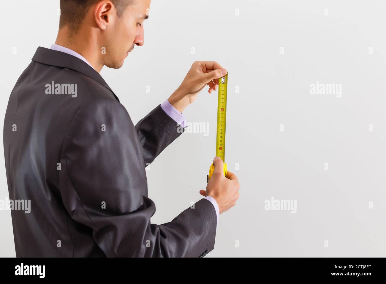 Businessman holding measurement tape, isolated on white background ...