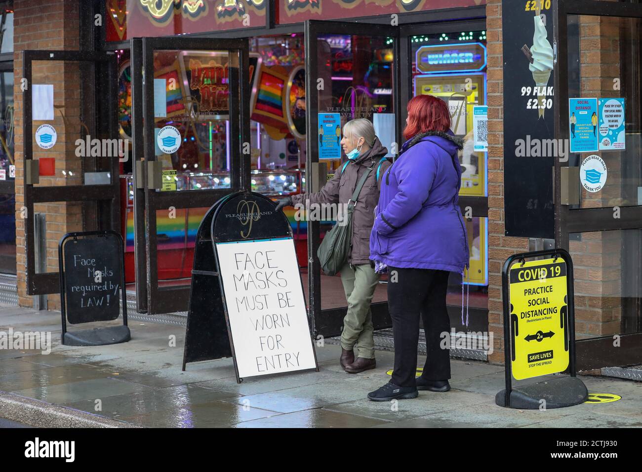 An amusement arcade worker takes a break outside the arcade where a ...