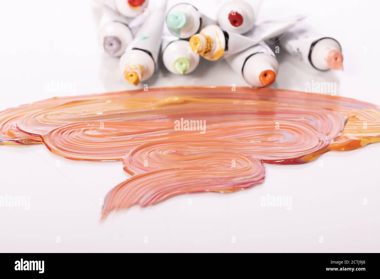 open tubes of colorful acrylic paint lying on glass table next to paint ...