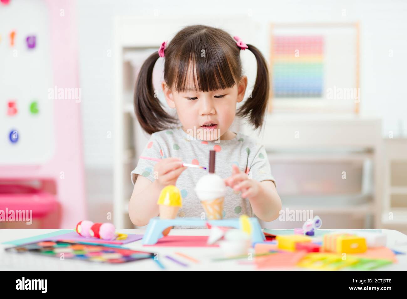young girl decorating hand made craft for homeschooling Stock Photo - Alamy