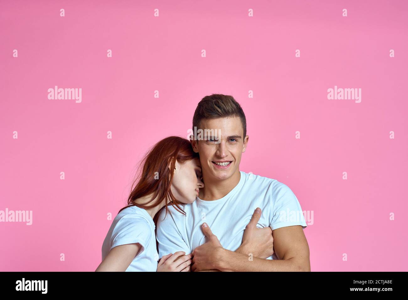 enamored man and woman hugging each other on a pink background cropped ...