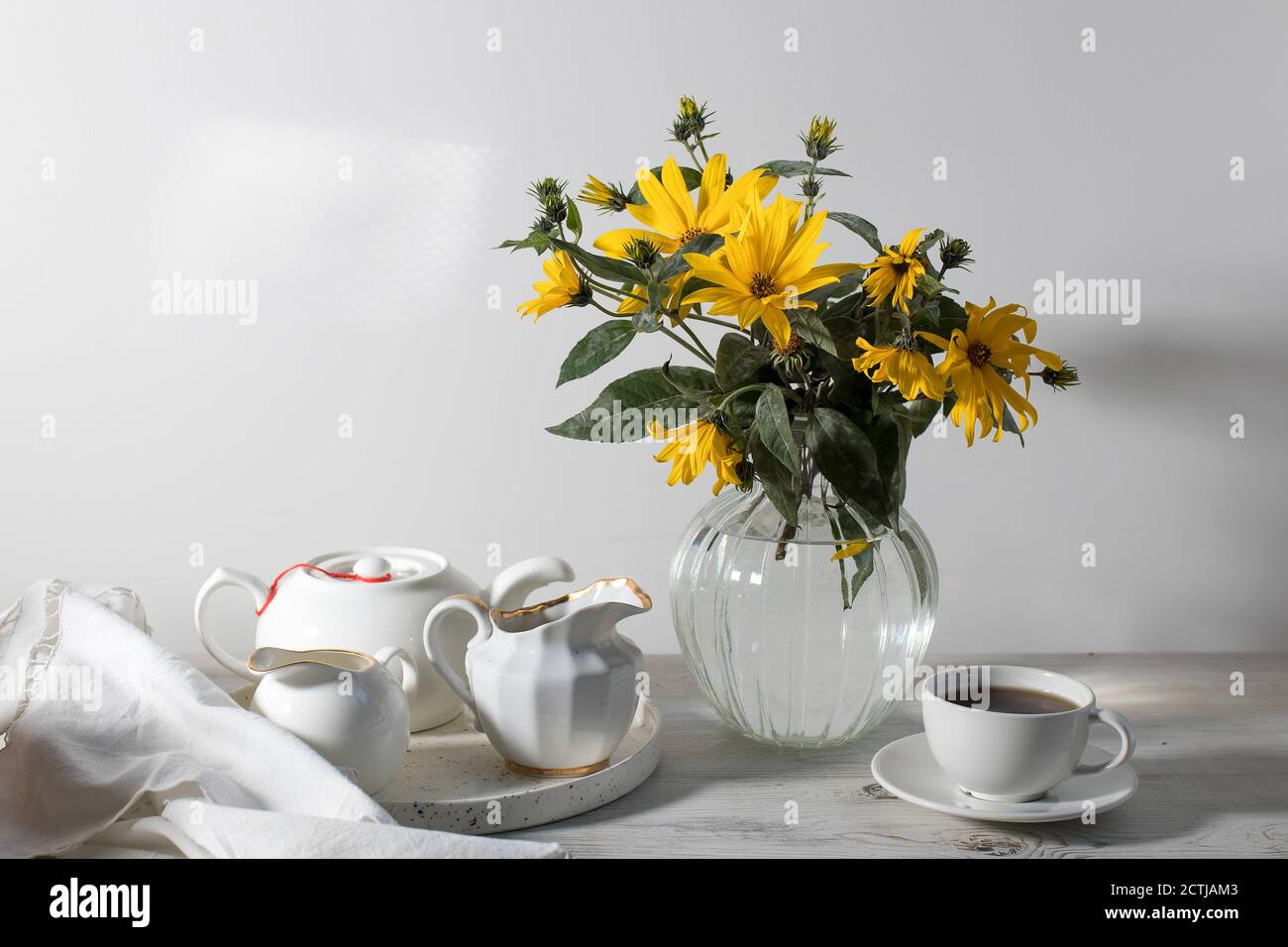 A bouquet of yellow jerusalem artichoke in a transparent vase on ...