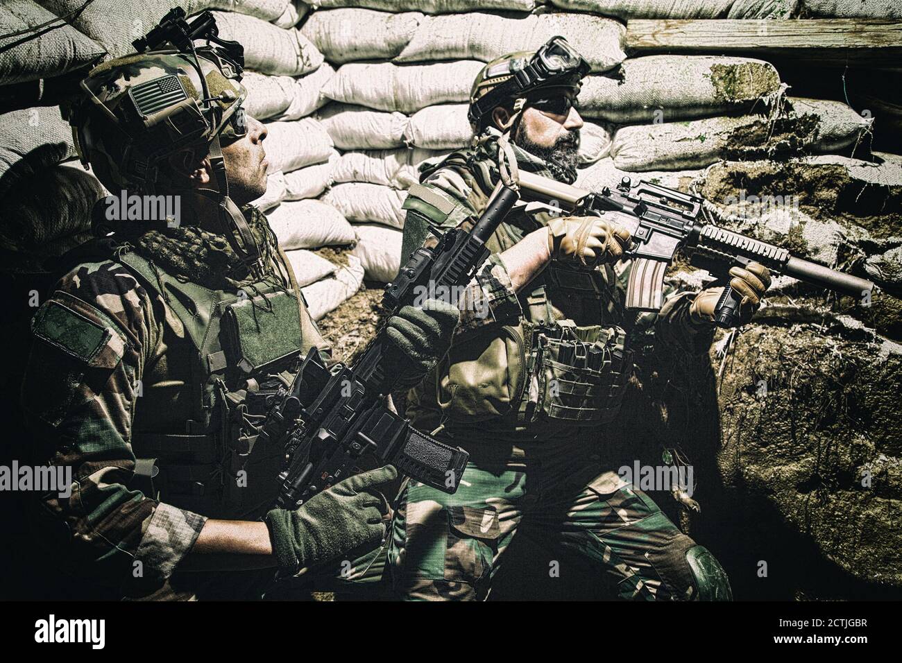Soldiers covering from enemy fire in trench. Two Navy SEALs fighters ...