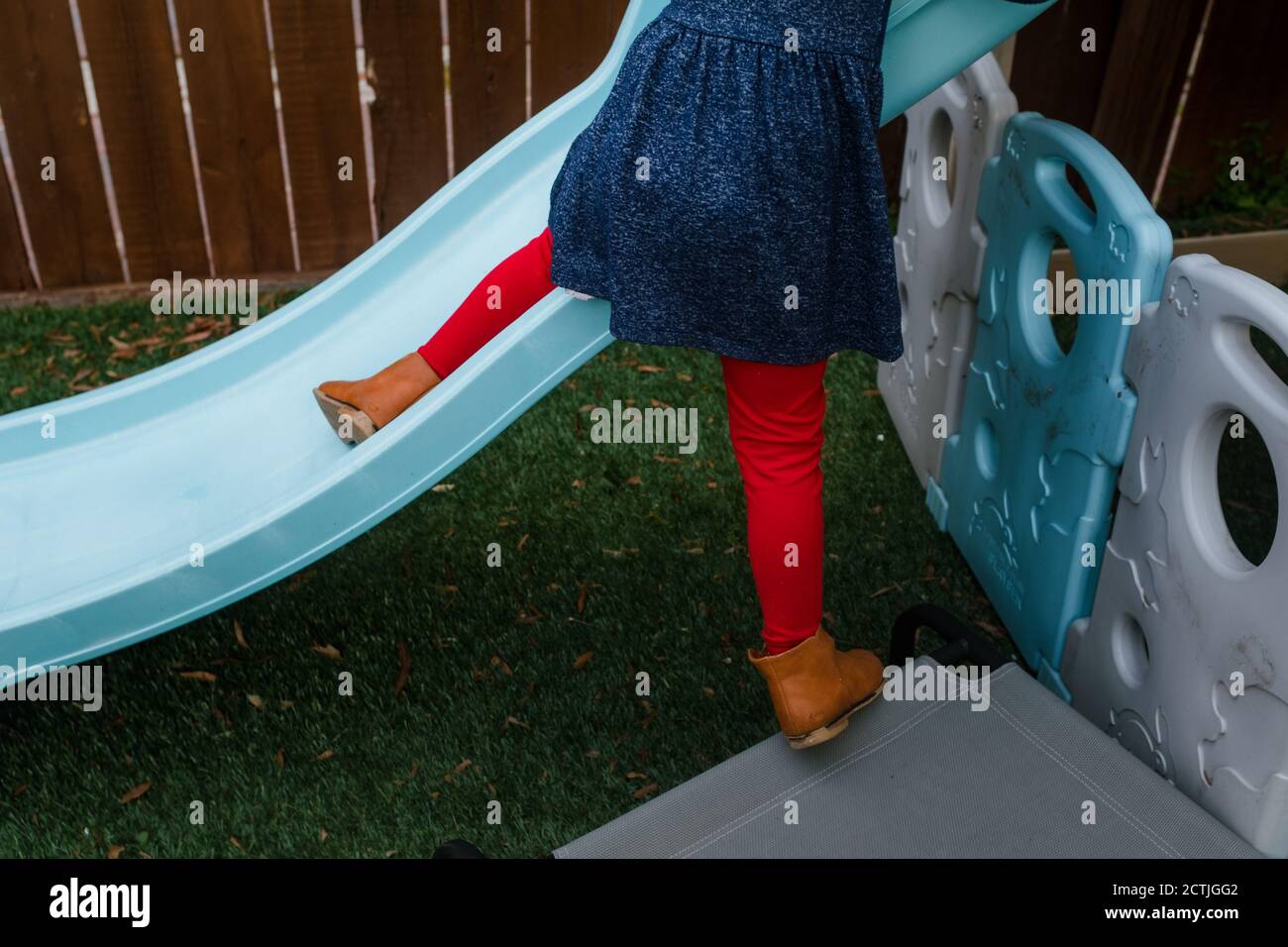 Little girl climbing on slide outside Stock Photo - Alamy