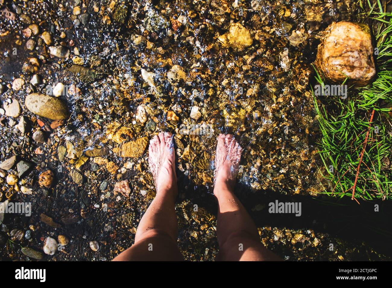 feet in the water of a river full of stones Stock Photo - Alamy