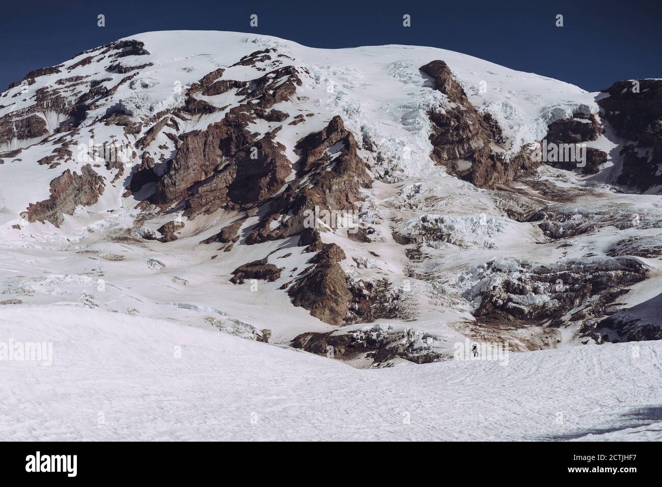 Snowboarded heading up mount Rainier for a mid summer ride Stock Photo ...