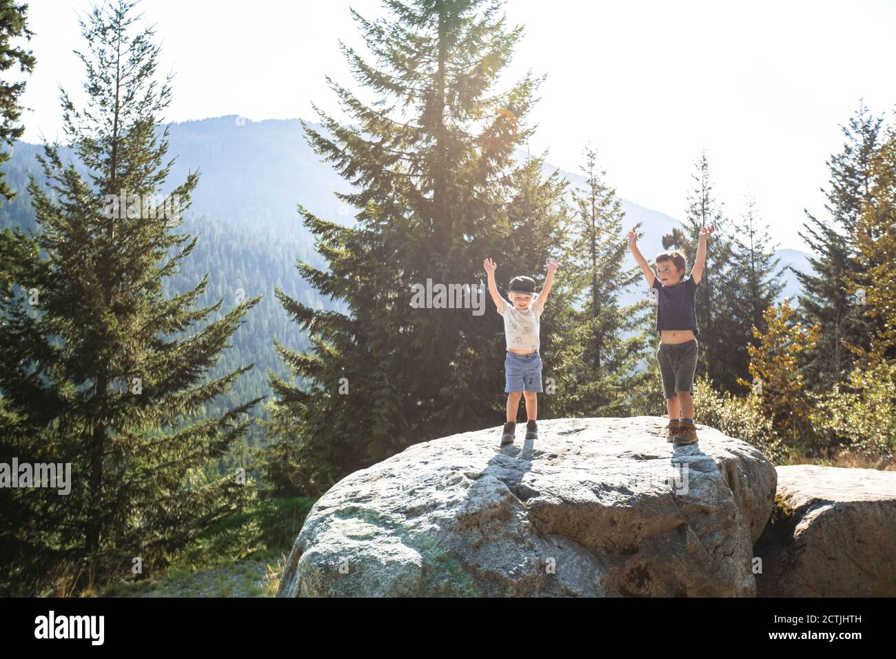 Two young hikers raise their hands in celebration, completing hike ...