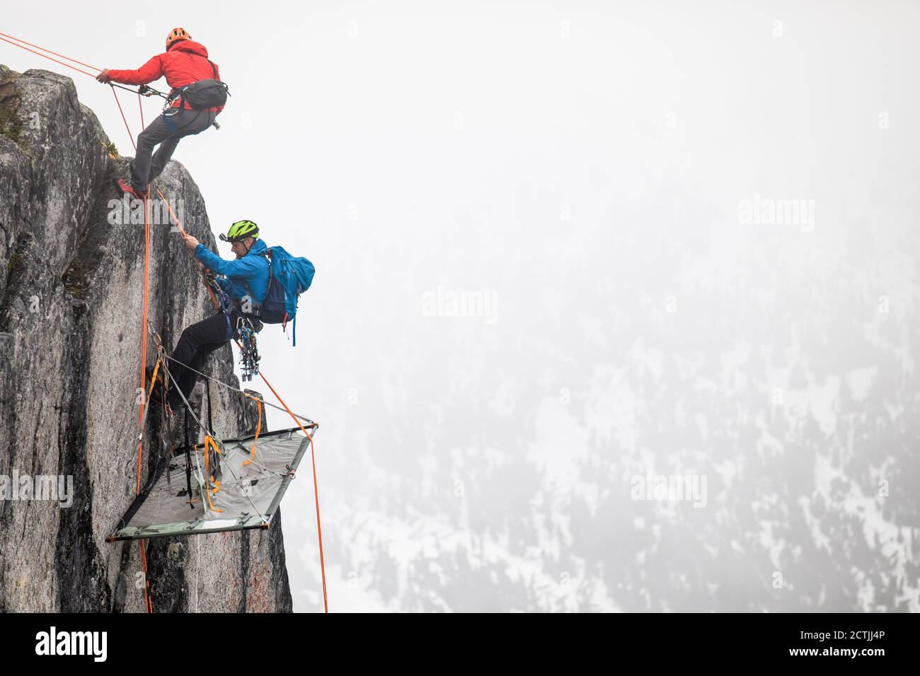 Climbers rappelling onto portaledge on a vertical cliff face Stock ...