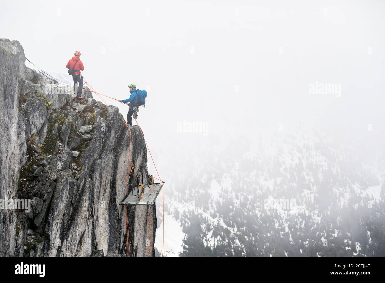 Climbers rappelling onto portaledge on a vertical cliff face Stock ...
