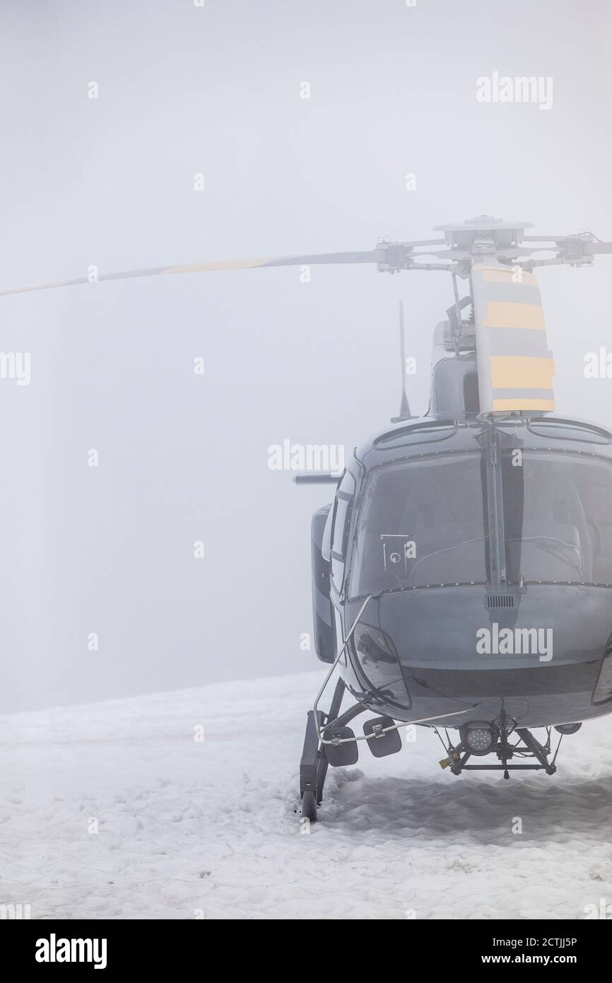 Helicopter landed on snow covered mountain summit Stock Photo - Alamy