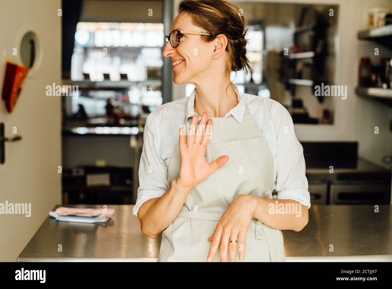 Smiling female chef wearing an apron in the restaurant kitchen Stock ...