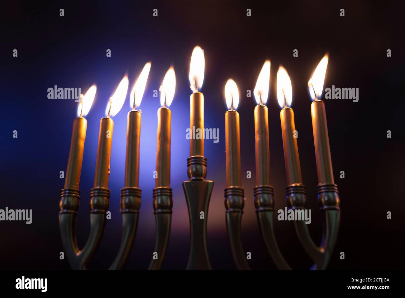 Lit Menorah in Celebration of Hanukah against Colored Background Stock ...