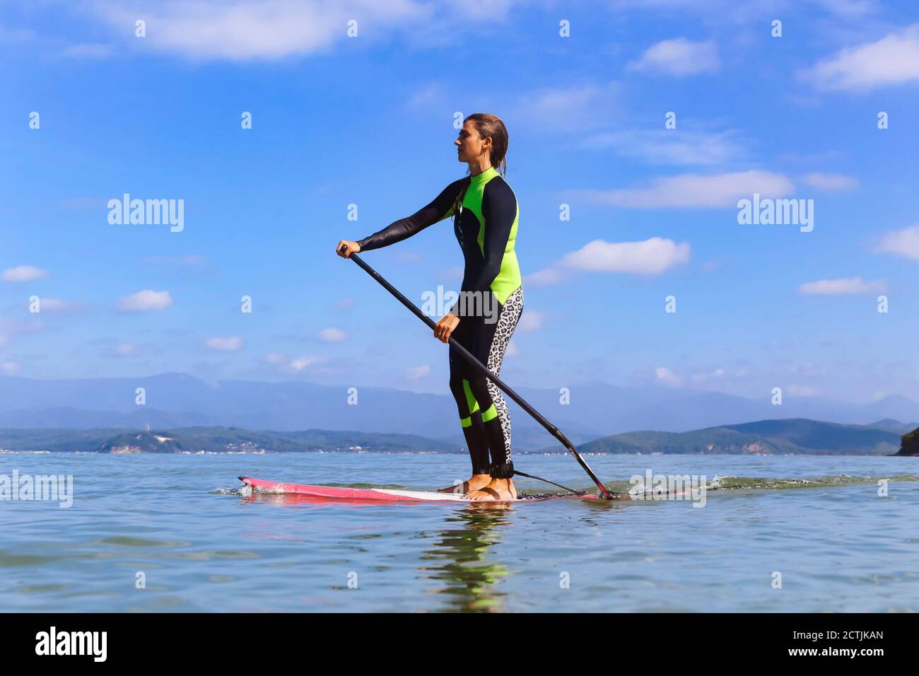 Female SUP surfer on a wave Stock Photo - Alamy