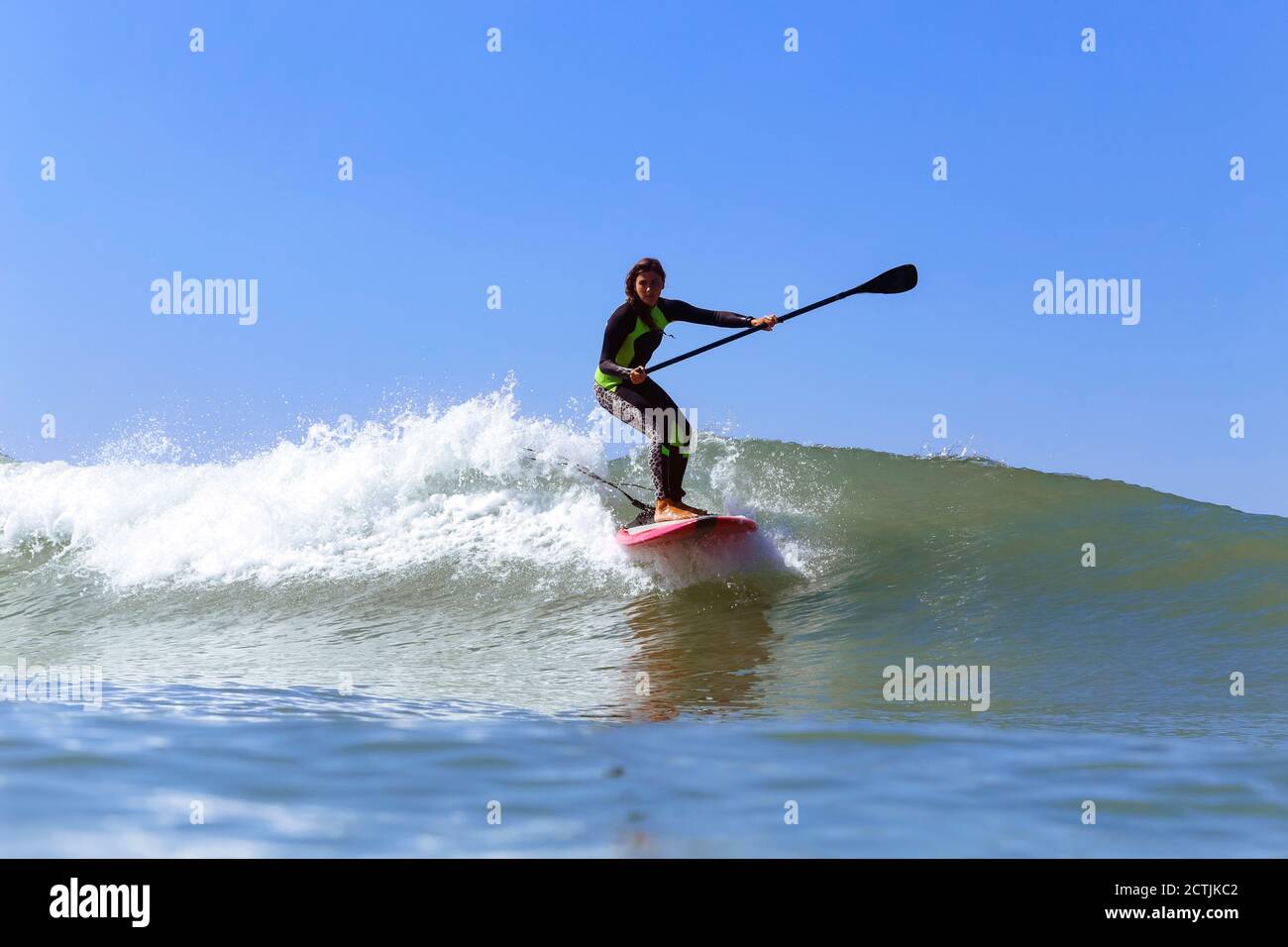 Female SUP surfer on a wave Stock Photo - Alamy