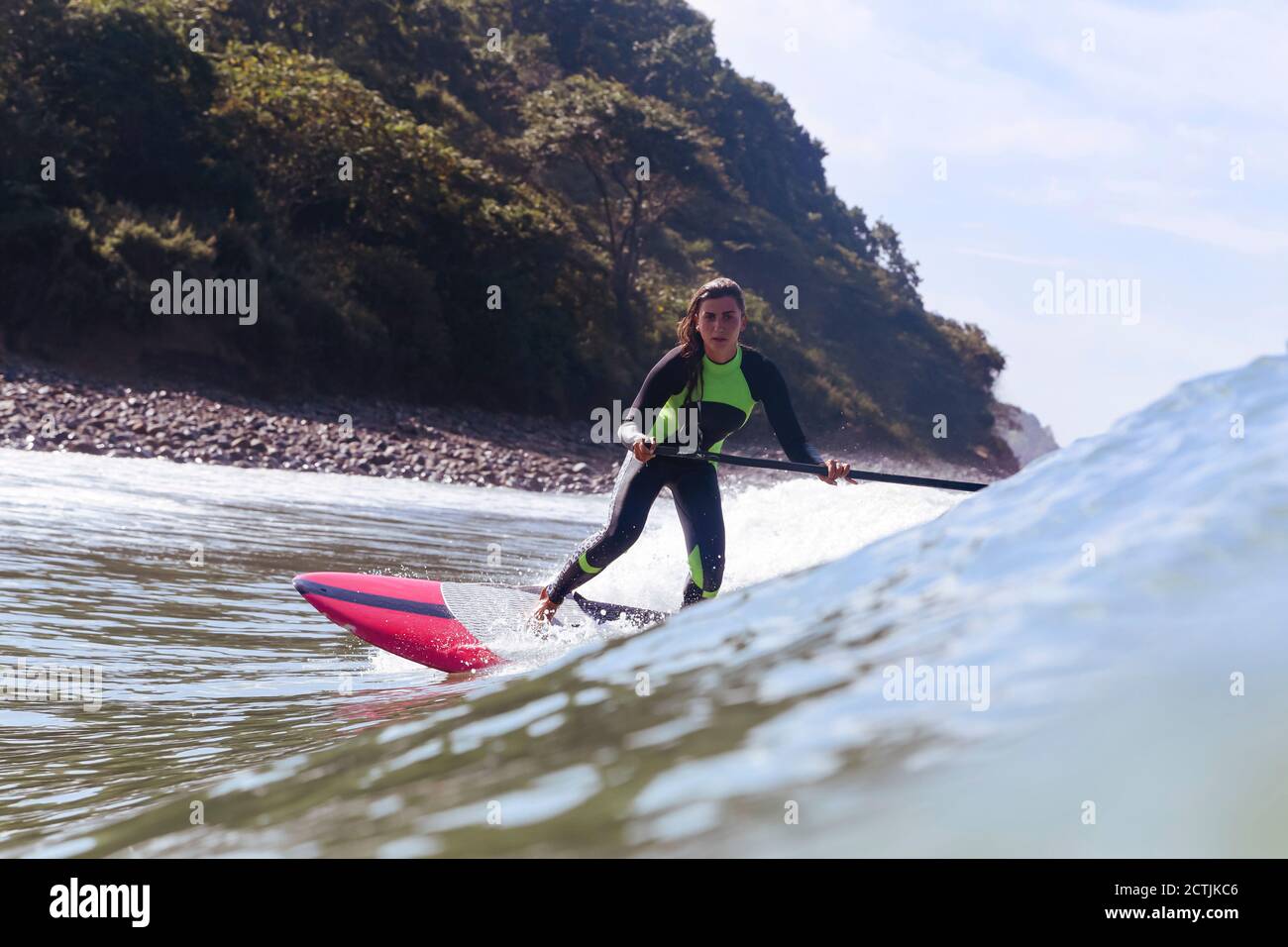 Female SUP surfer on a wave Stock Photo - Alamy