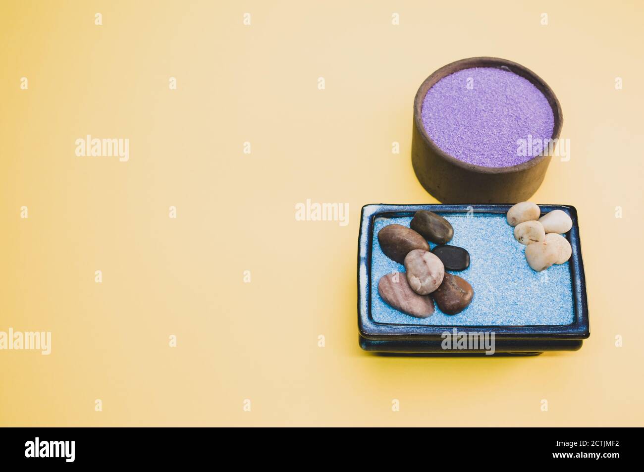 Shot of colored violet sand in bowls with some natural stones Stock ...