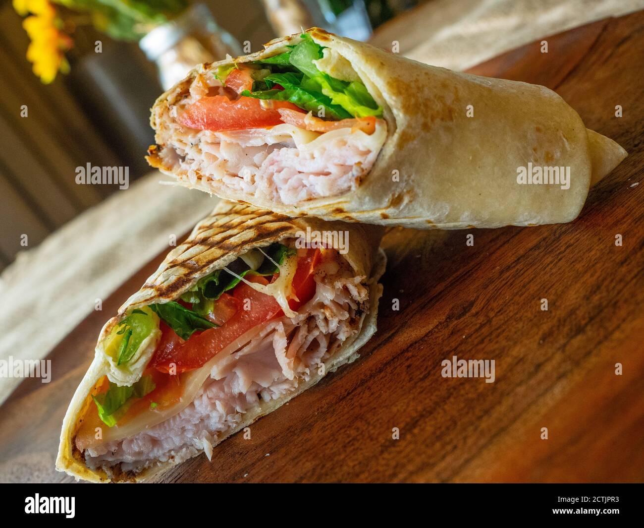 Closeup shot of a burrito cut in half on a wooden plate Stock Photo - Alamy