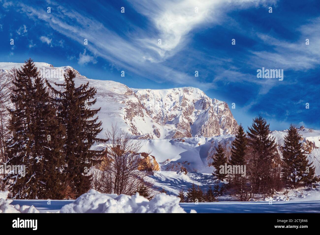 Beautiful mountains covered in snow and gleaming under the cloudy sky ...