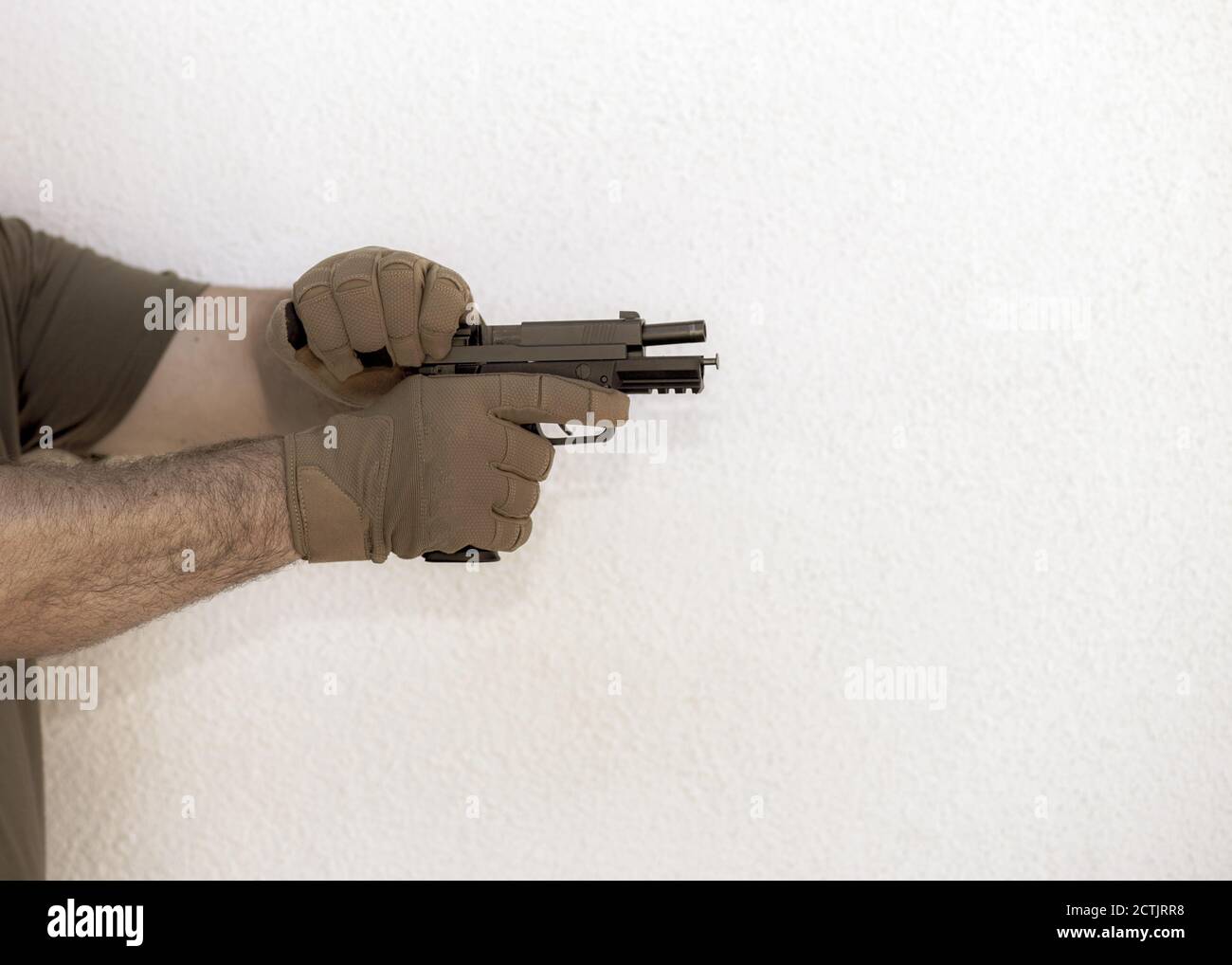 Military man wearing gloves and reloading his handgun Stock Photo - Alamy