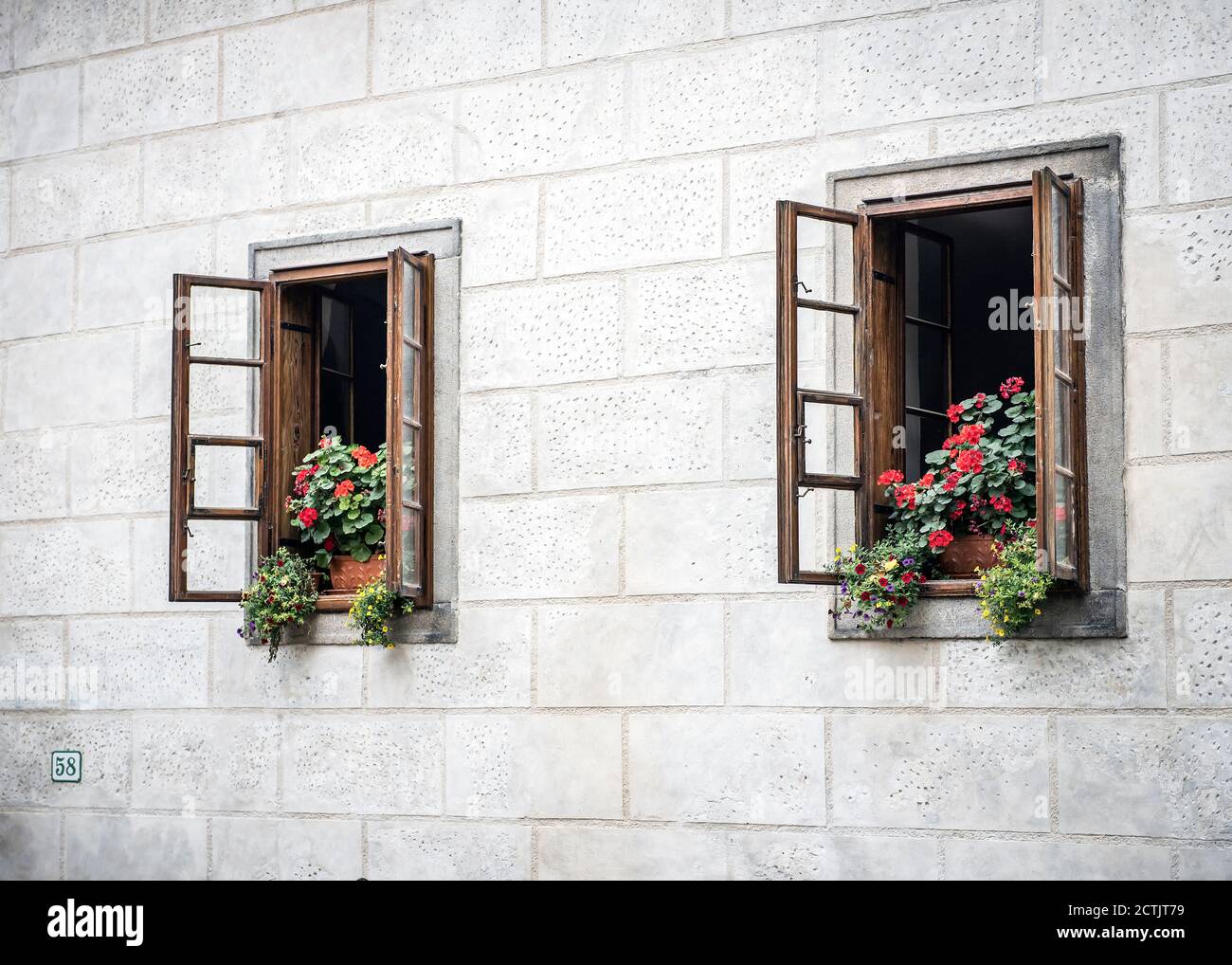 Wooden windows with flowers in the old sandstone house Stock Photo - Alamy