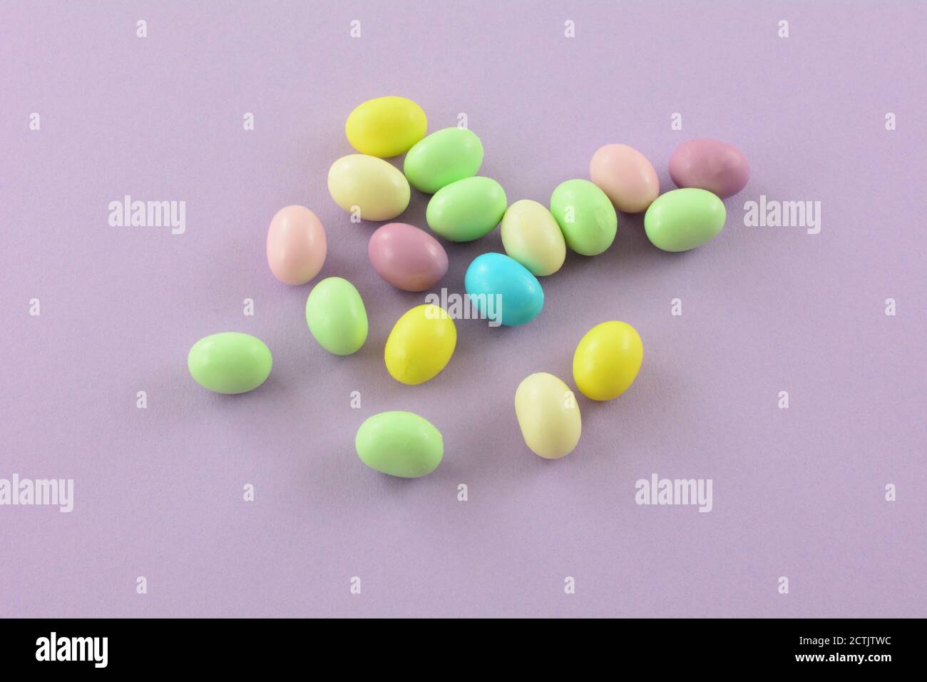 White chocolate covered fruit gummy candy in pastel colors on lavender ...