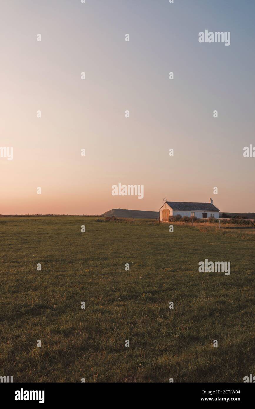 Lonely cottage - sun setting at St. Aldhelm’s Head near Swanage on the ...
