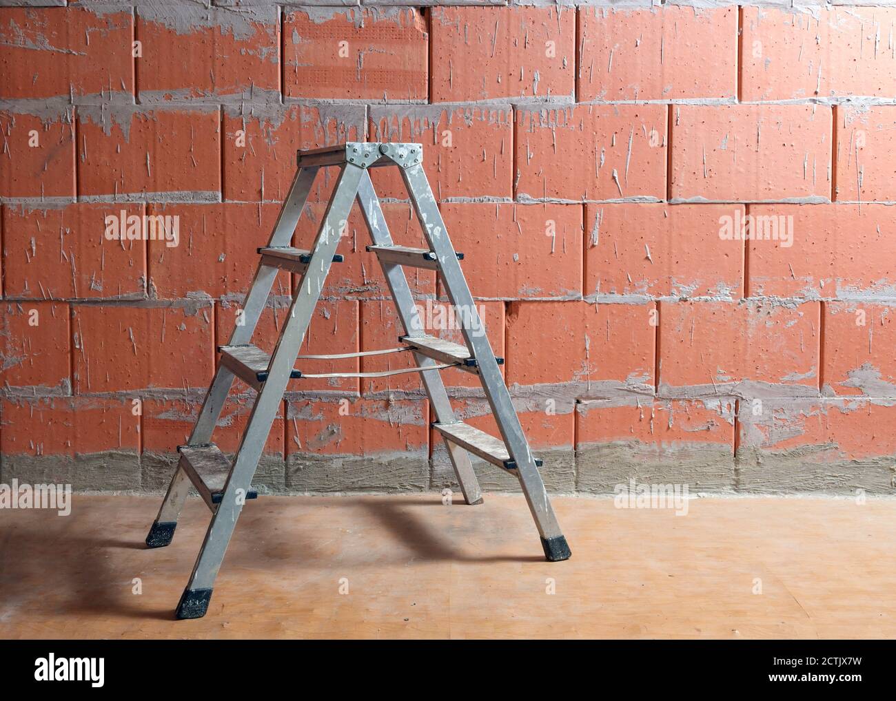 Small step ladder in front of a raw brick wall from Porotherm style ...