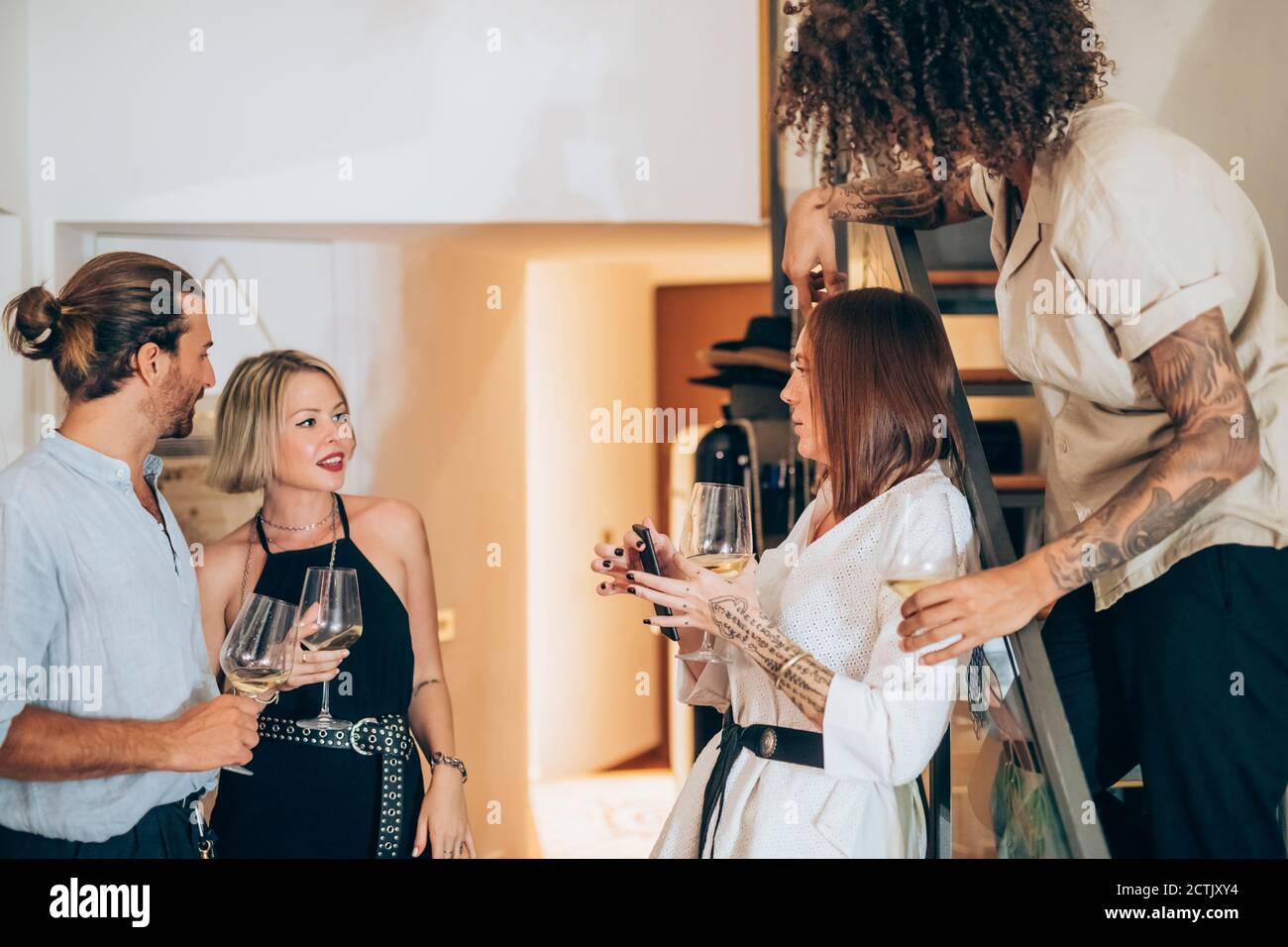 Young friends talking while drinking wine during party at home Stock ...
