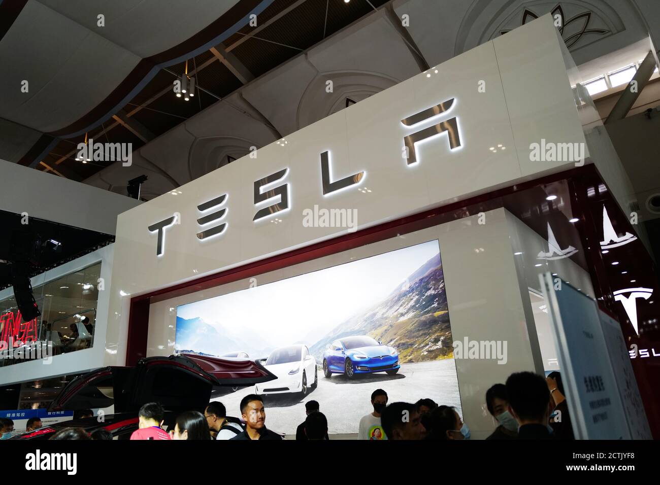 Visitors flock to the booth of Tesla, an American electric vehicle and ...