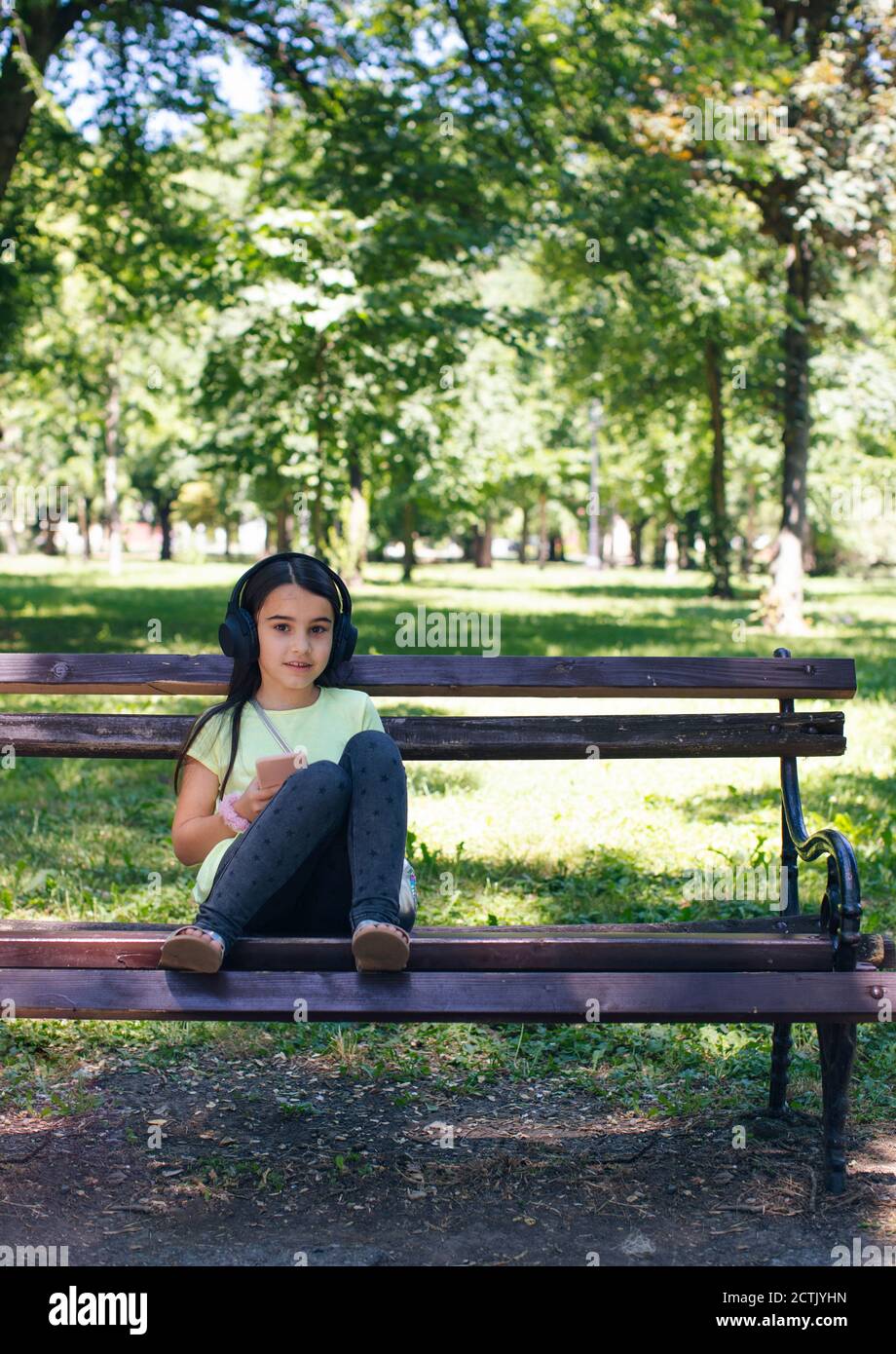 Girl sitting on park bench hi-res stock photography and images - Alamy